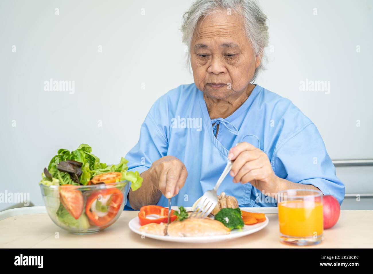 Asian senior or elderly old lady woman patient eating Salmon steak ...