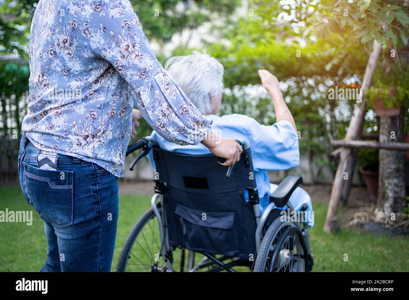 Caregiver help and care Asian senior or elderly old lady woman patient sitting on wheelchair at ...