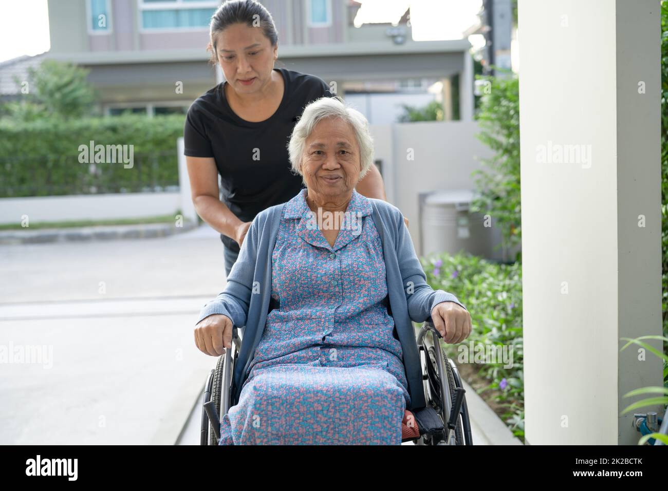 Caregiver help and care Asian senior or elderly old lady woman patient sitting on wheelchair at ...