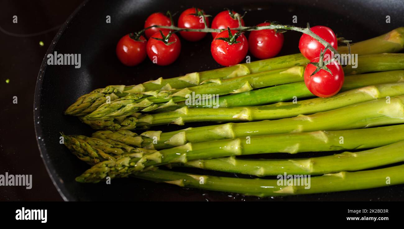 Green asparagus with small vine tomatoes Stock Photo - Alamy