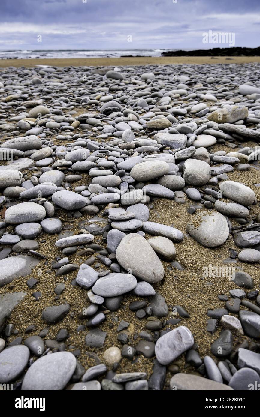 Stones in sand beach Stock Photo - Alamy