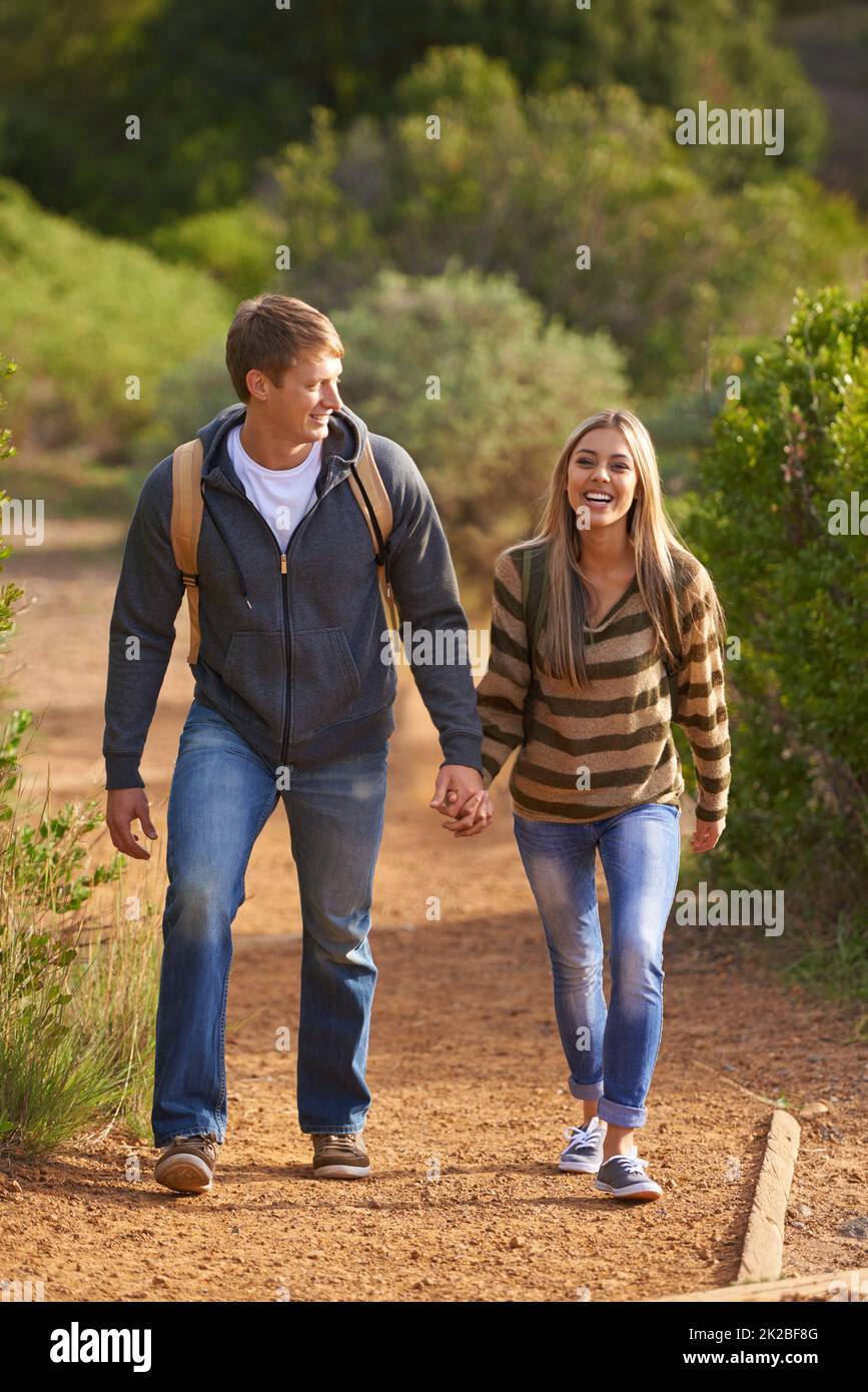 True love pulls you up the hills. a happy young couple walking on a ...