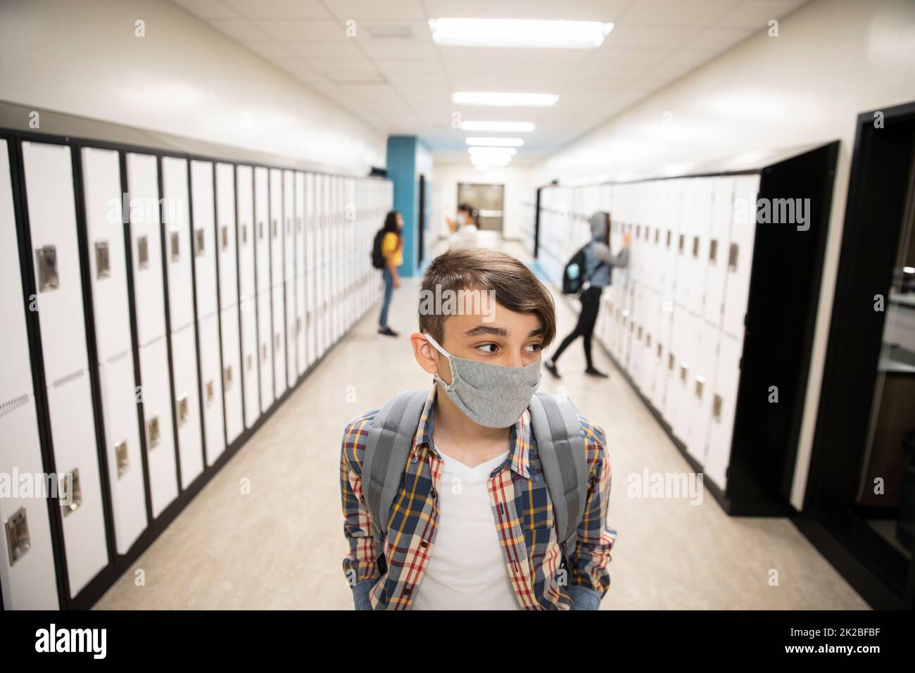 Student in school corridor wearing face mask Stock Photo - Alamy