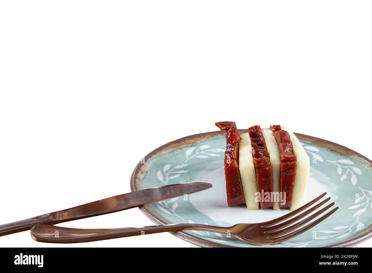 Guava sweet and curd cheese slices next to cutlery white background ...