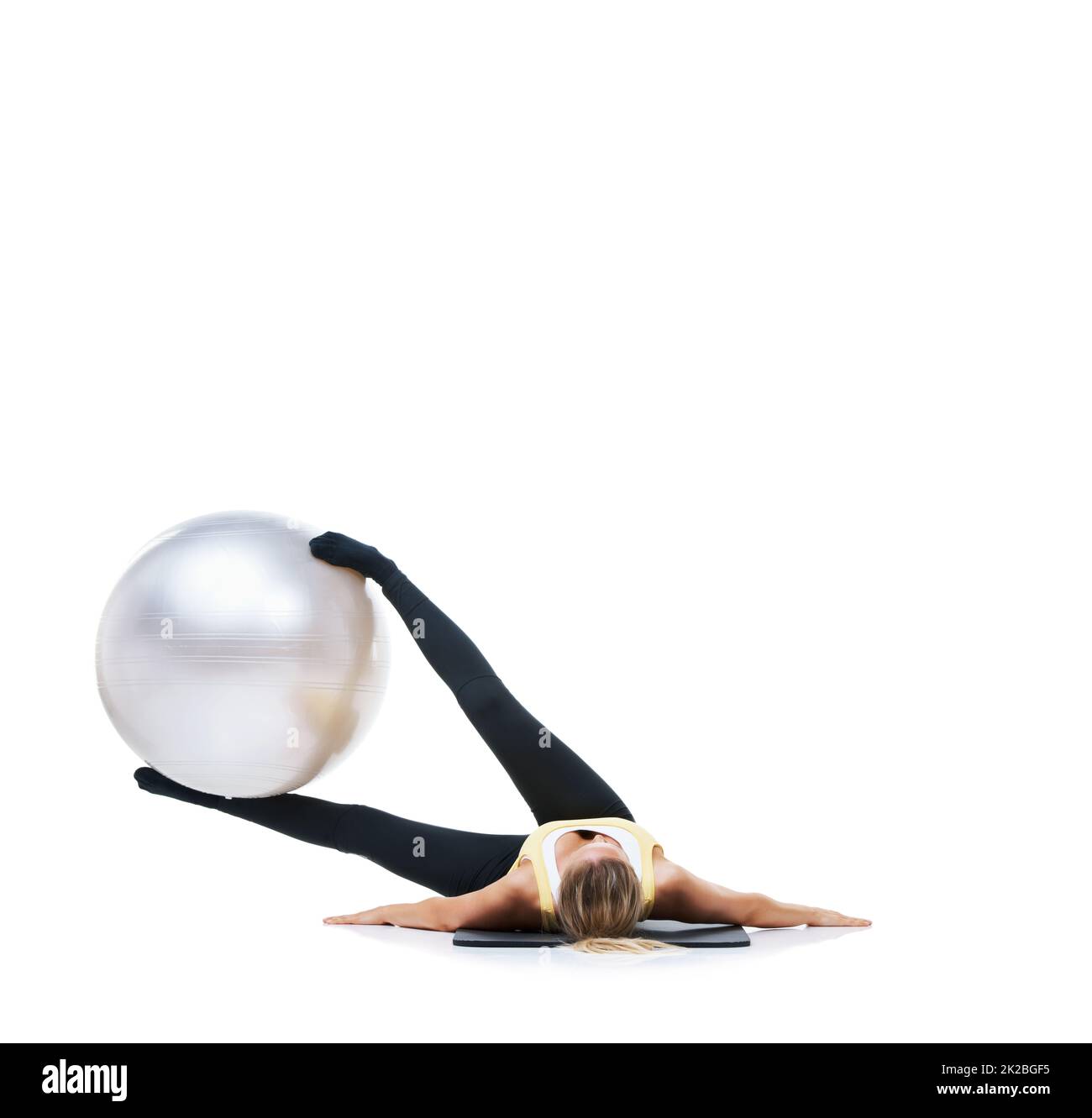 Balancing and staying fit. Shot of a female holding an exercise ball up ...