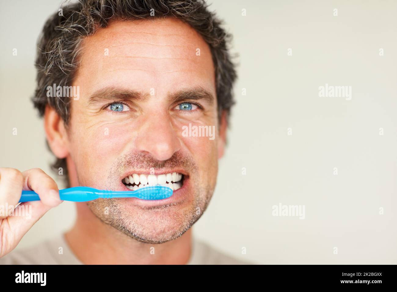 Handsome man brushing teeth. Closeup of handsome mature man brushing ...