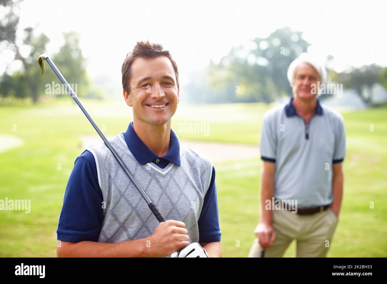 Male golfer smiling. Portrait of man holding a golf club and smiling ...