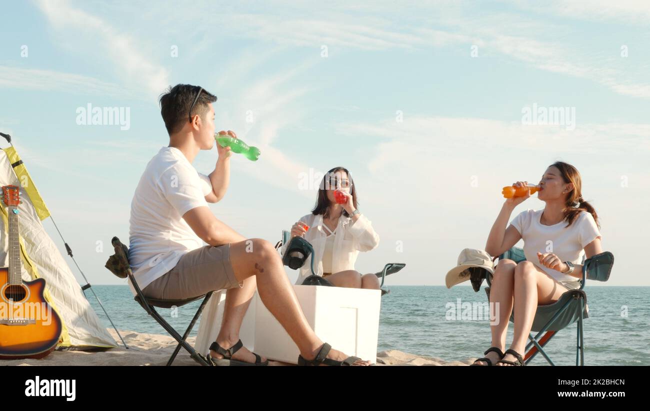 Happy friends with drinks in camp and laughing together in holidays on ...