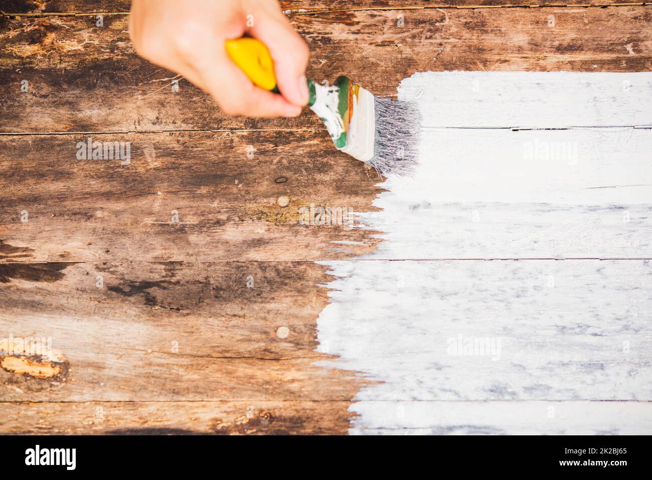 hand using paintbrush decorating or painting old wood brown color to ...