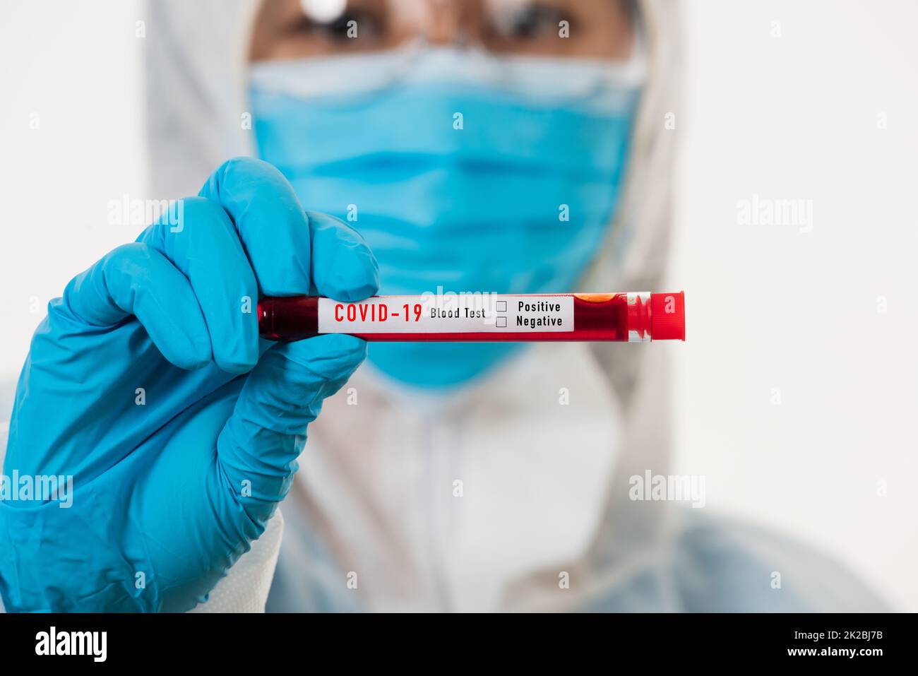 Medical scientist in PPE uniform wear a mask holding test tube ...