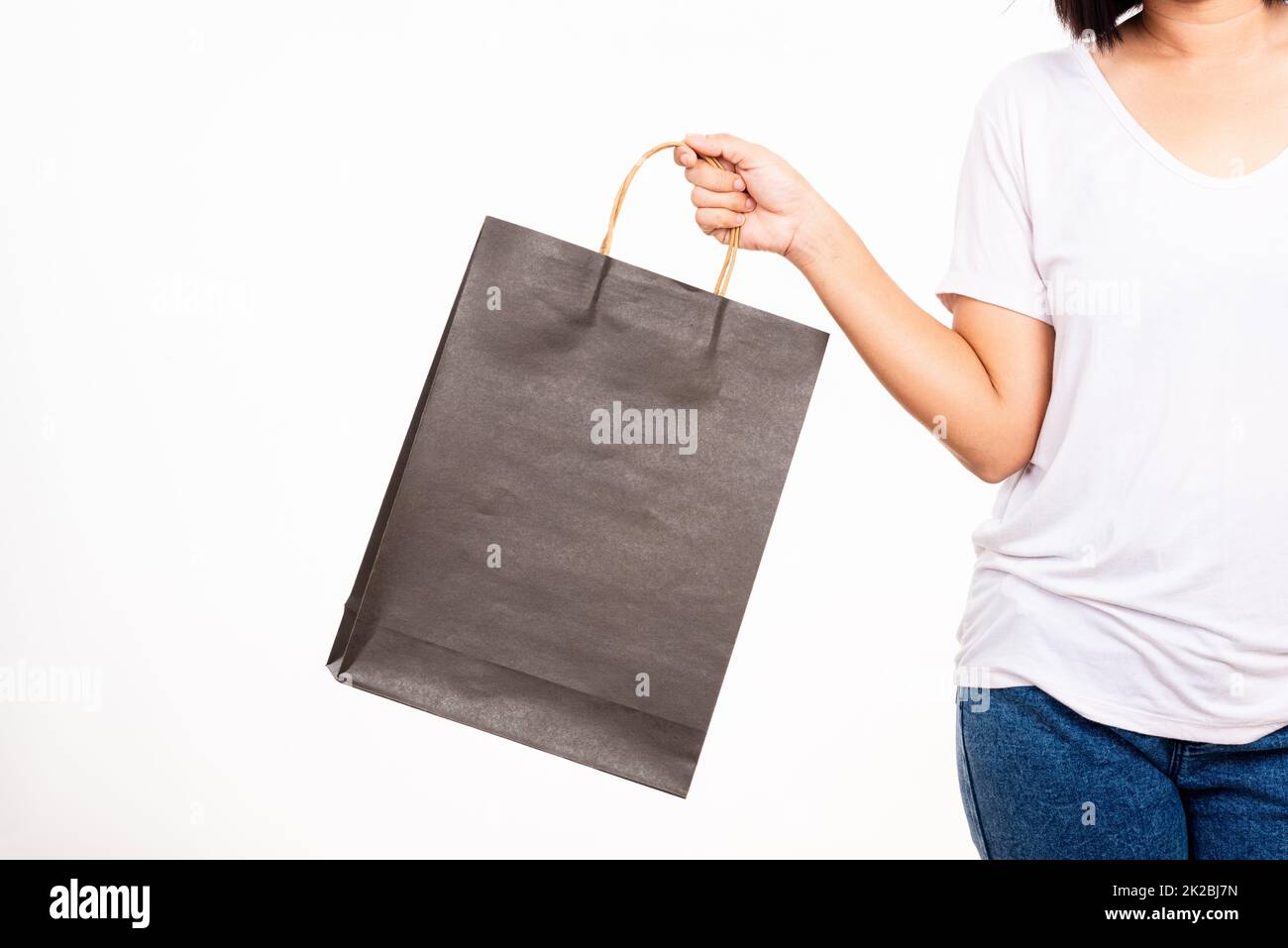 female holds in hand with black clear empty blank craft paper gift bag ...