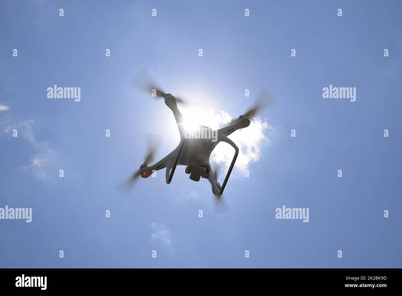 Drone DJI Phantom 4 in flight. Quadrocopter against the blue sky with ...