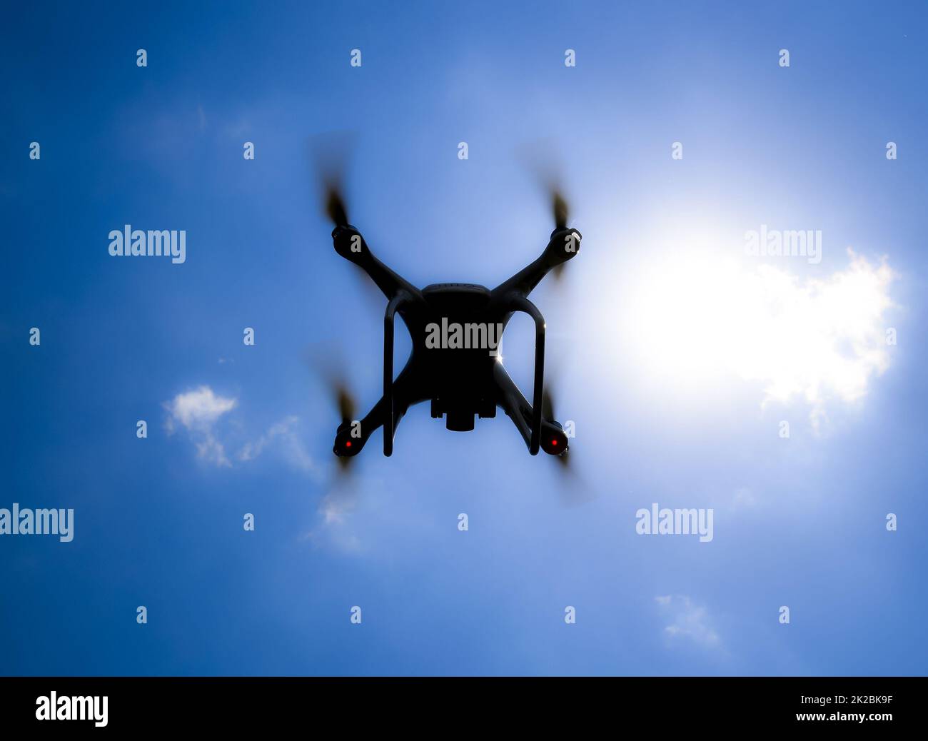 Drone DJI Phantom 4 in flight. Quadrocopter against the blue sky with ...