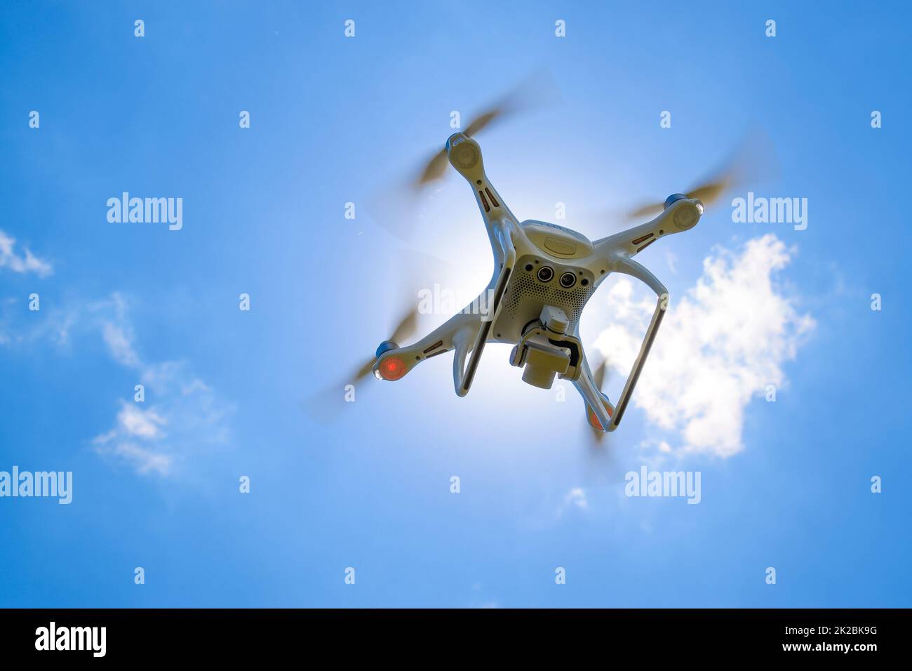 Drone DJI Phantom 4 in flight. Quadrocopter against the blue sky Stock ...