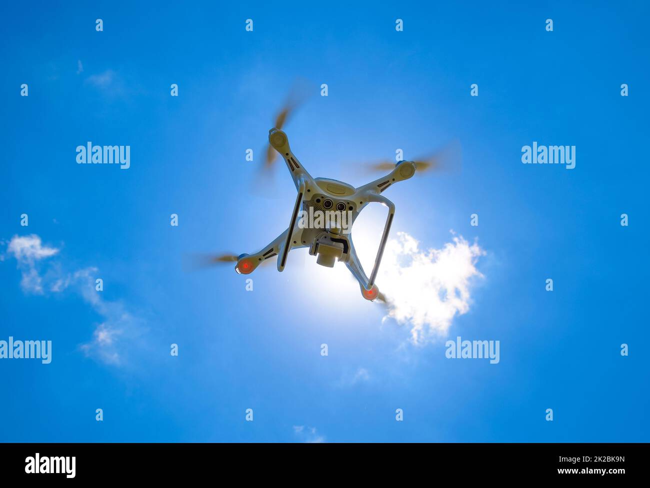 Drone DJI Phantom 4 in flight. Quadrocopter against the blue sky Stock ...