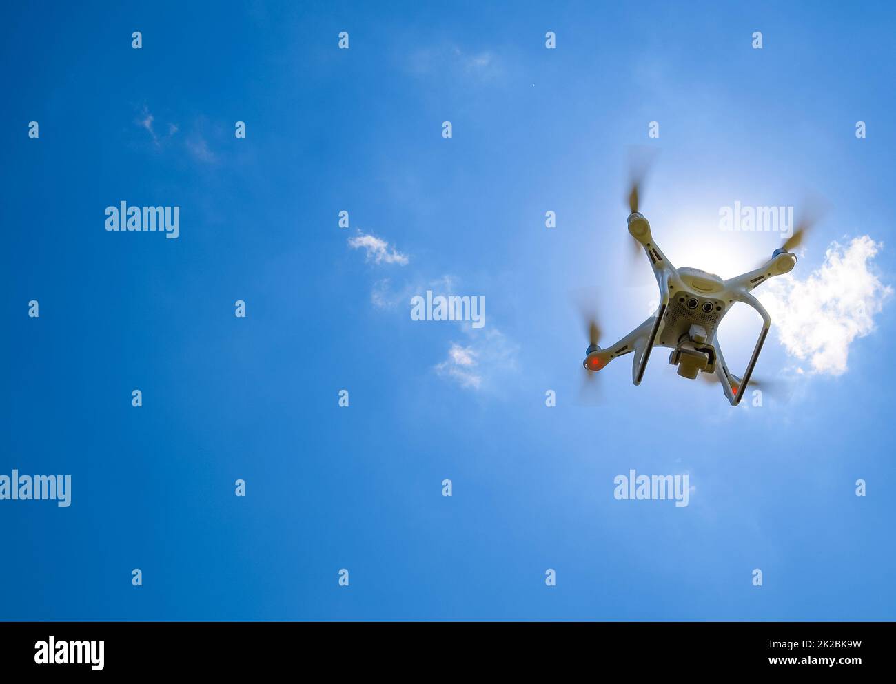 Drone DJI Phantom 4 in flight. Quadrocopter against the blue sky Stock ...