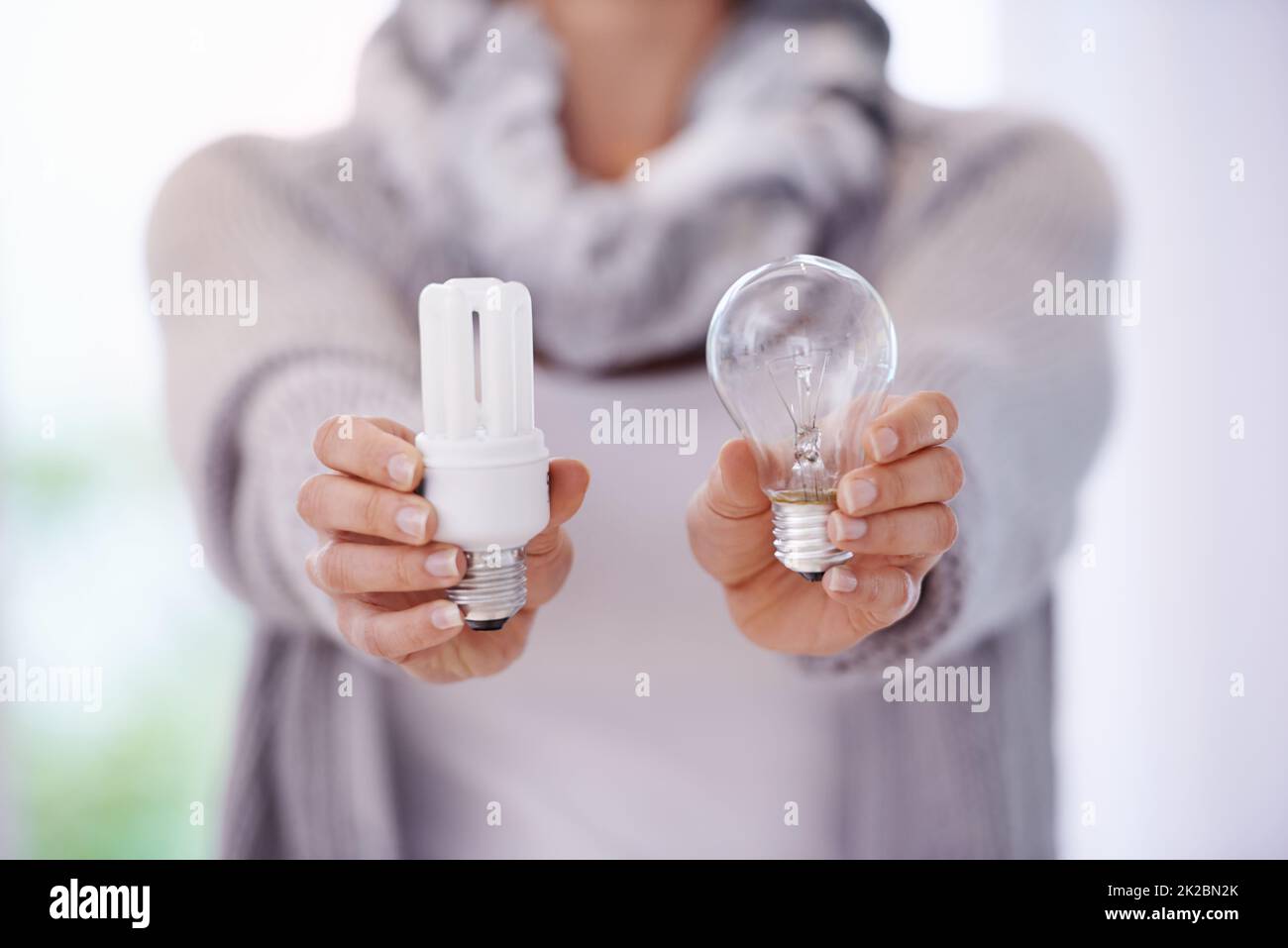 Keep the lights burning longer. A cropped image of a woman holding two ...