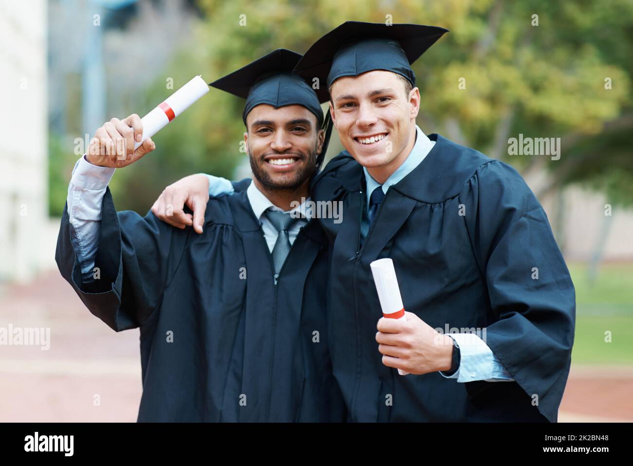 Were on our way to success. Two young college graduates holding their ...