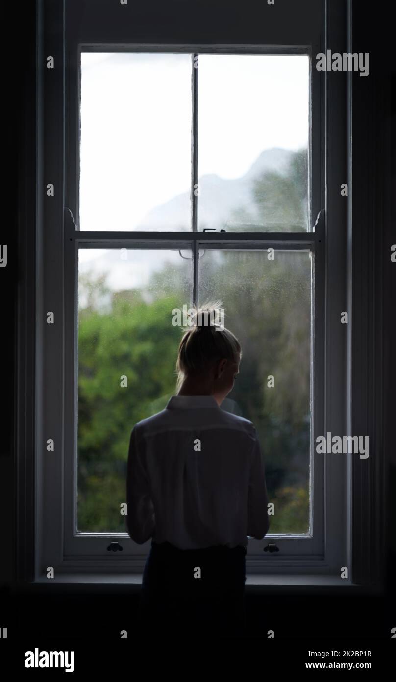 Room with a view. A beautiful young woman standing by a window Stock ...
