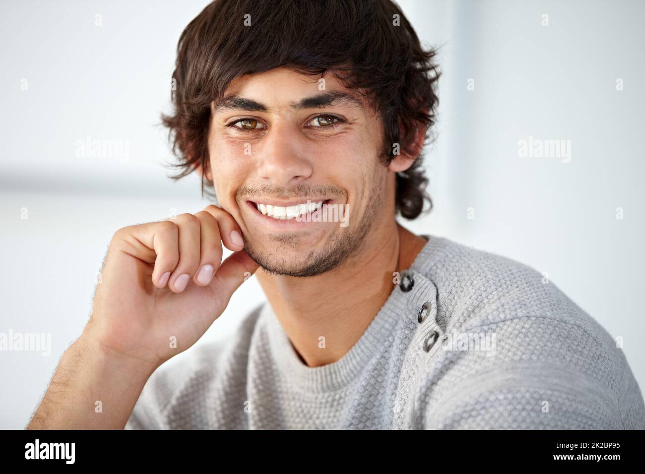 Having a good day at work. Handsome young man smiling while against a ...