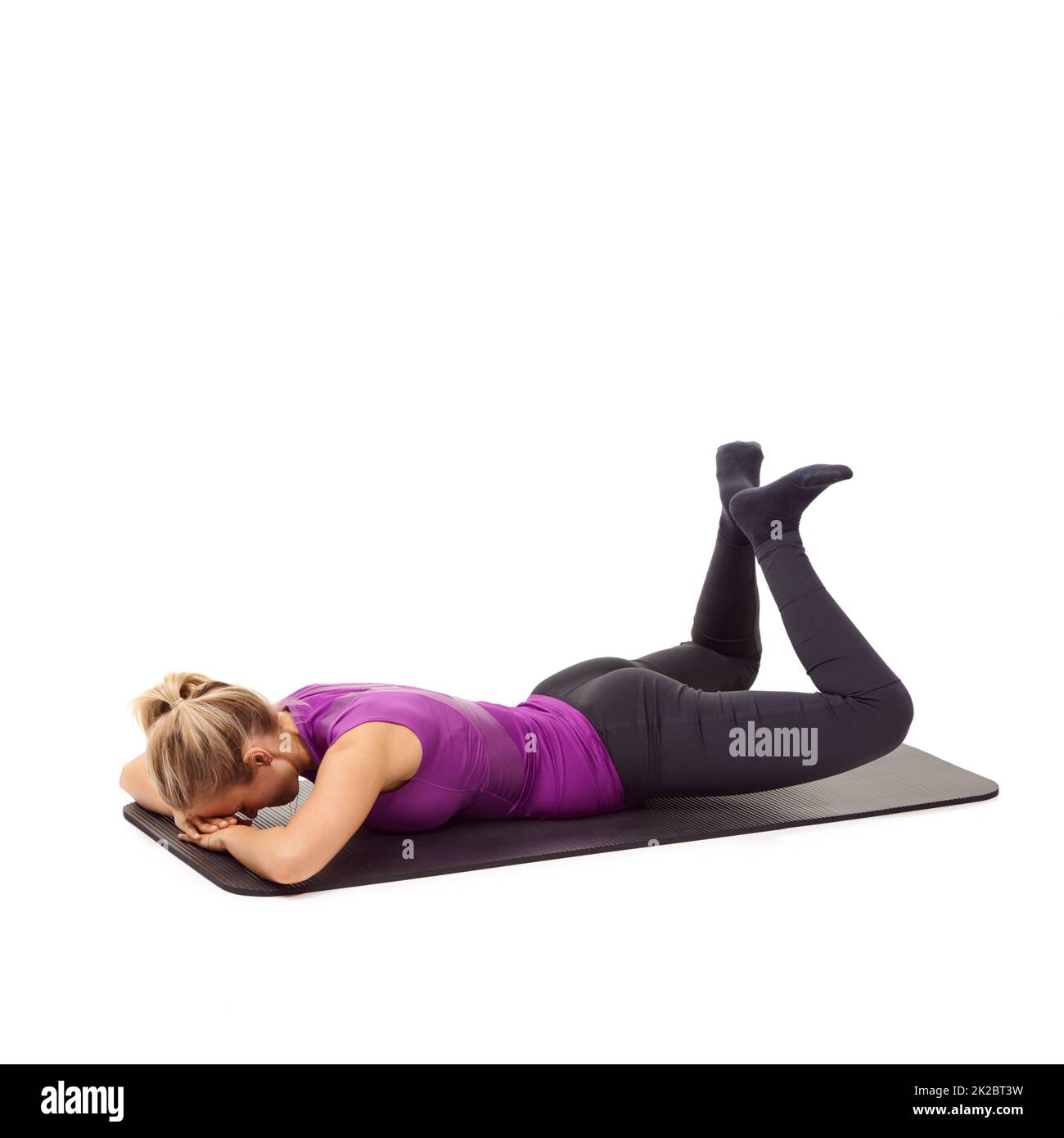 Doing clenches. A young woman lying on her stomach and clenching her ...