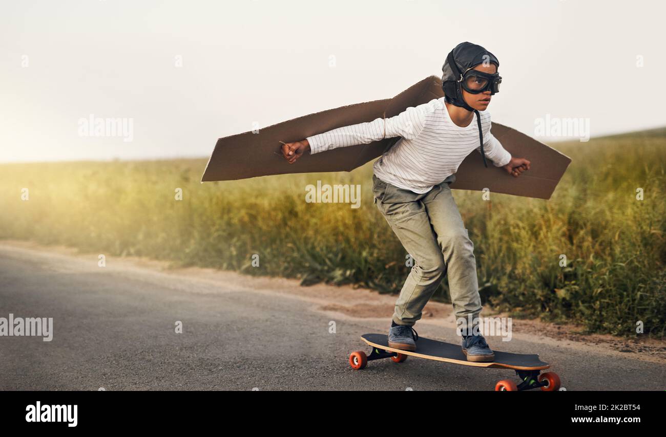 Ready, steady, fly. Shot of a young boy pretending to fly with a pair ...