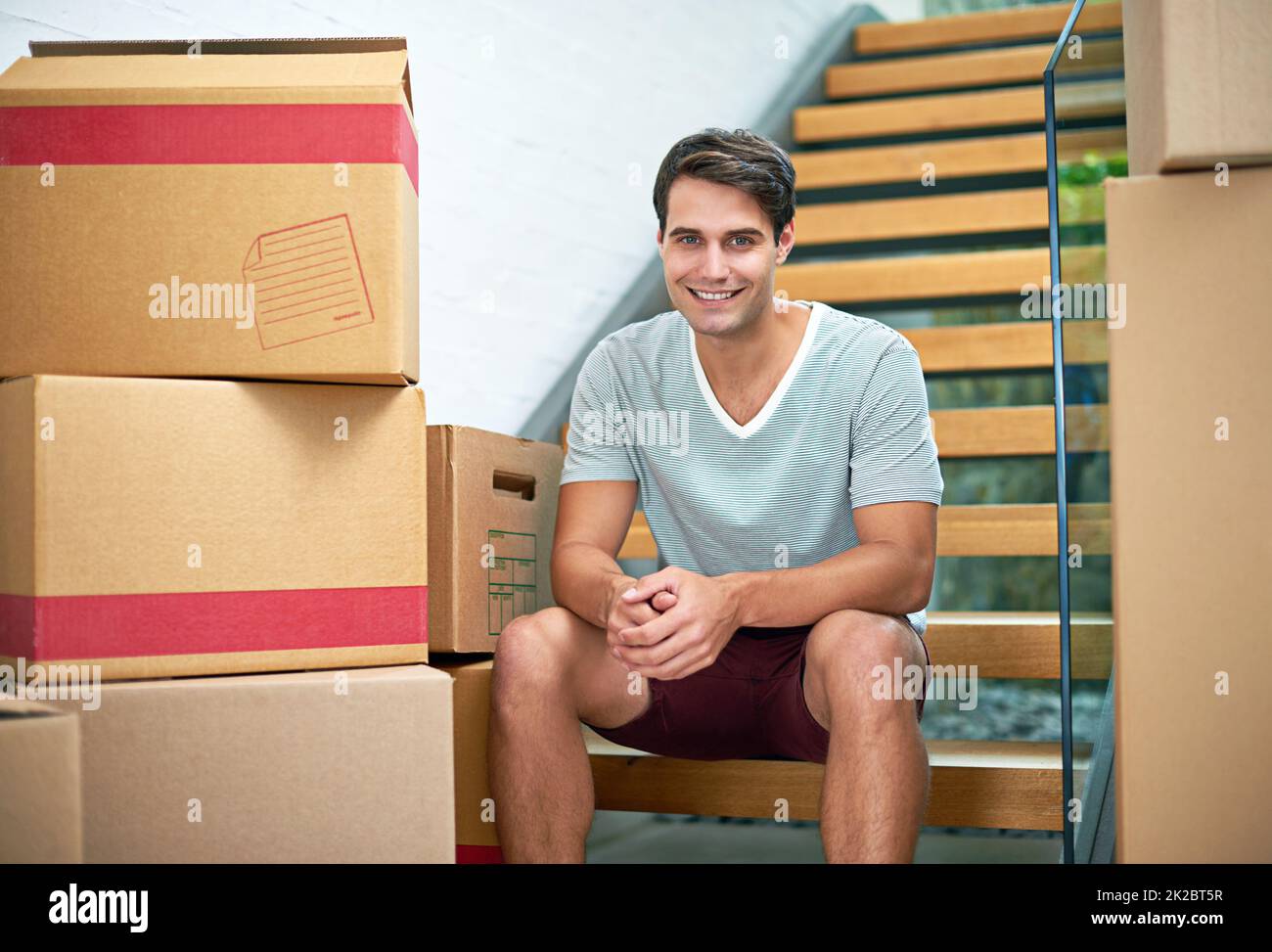 The start of a new chapter. Portrait of a young man sitting in his new ...
