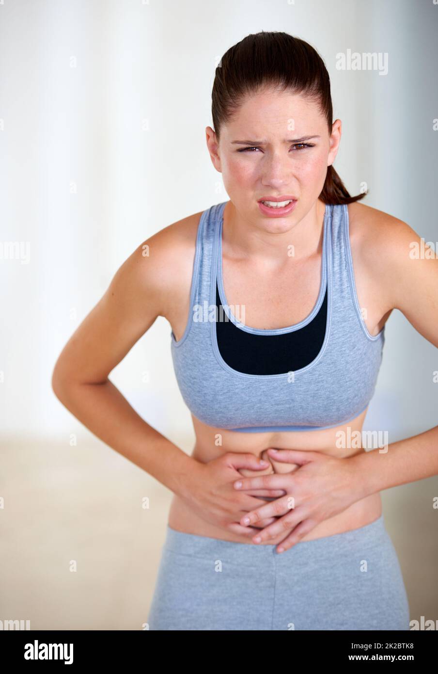 Stomach ache. Portrait of an attractive young woman holding her stomach ...