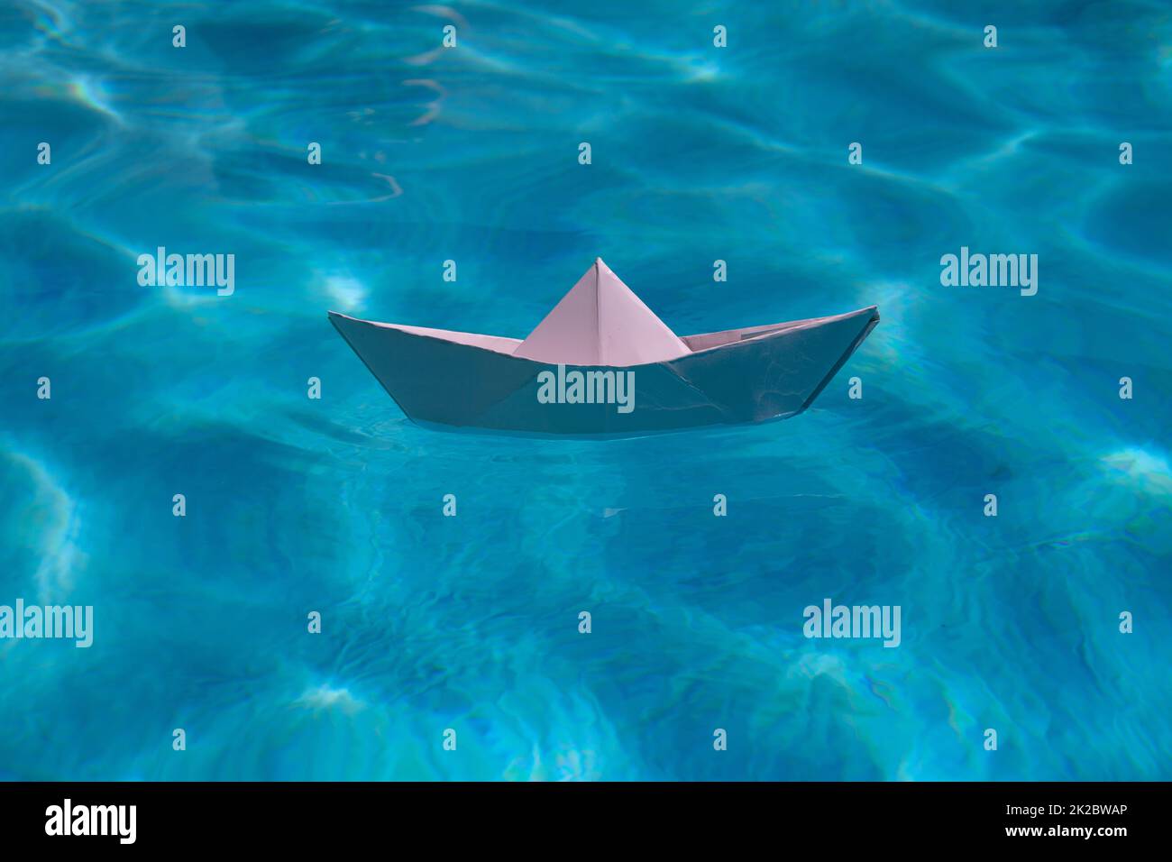 Paper boat sailing on water causing waves and ripples. Paper boat into ...