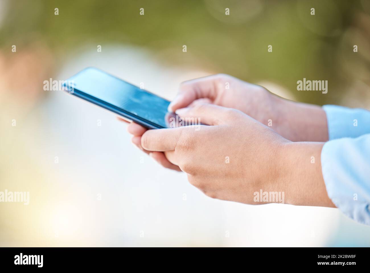Communication, social media and a man typing on a phone in a park with ...