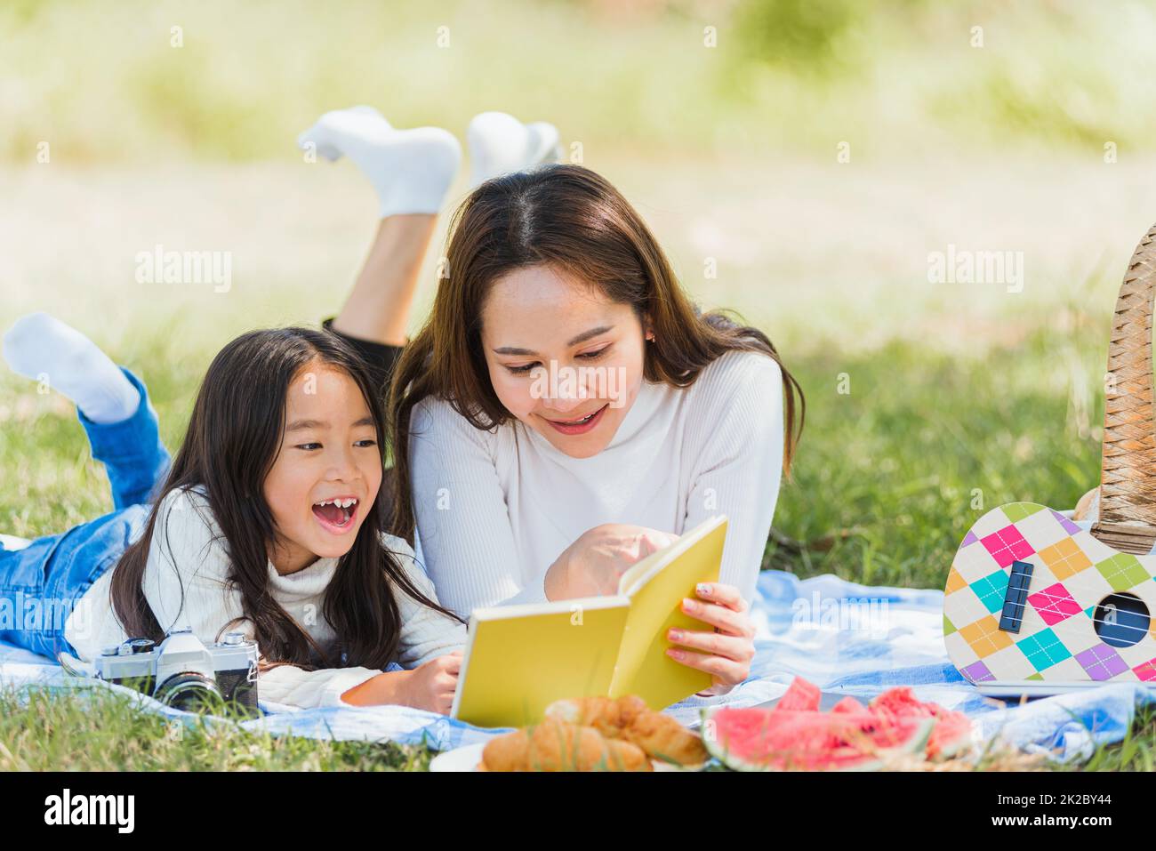 Happy family having fun and enjoying outdoor laying on picnic blanket ...