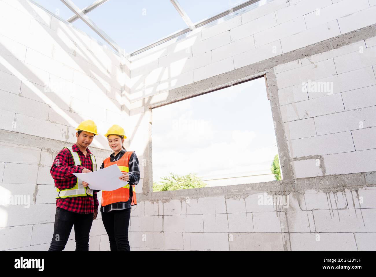 Architect and client discussing the plan with blueprint of the building ...