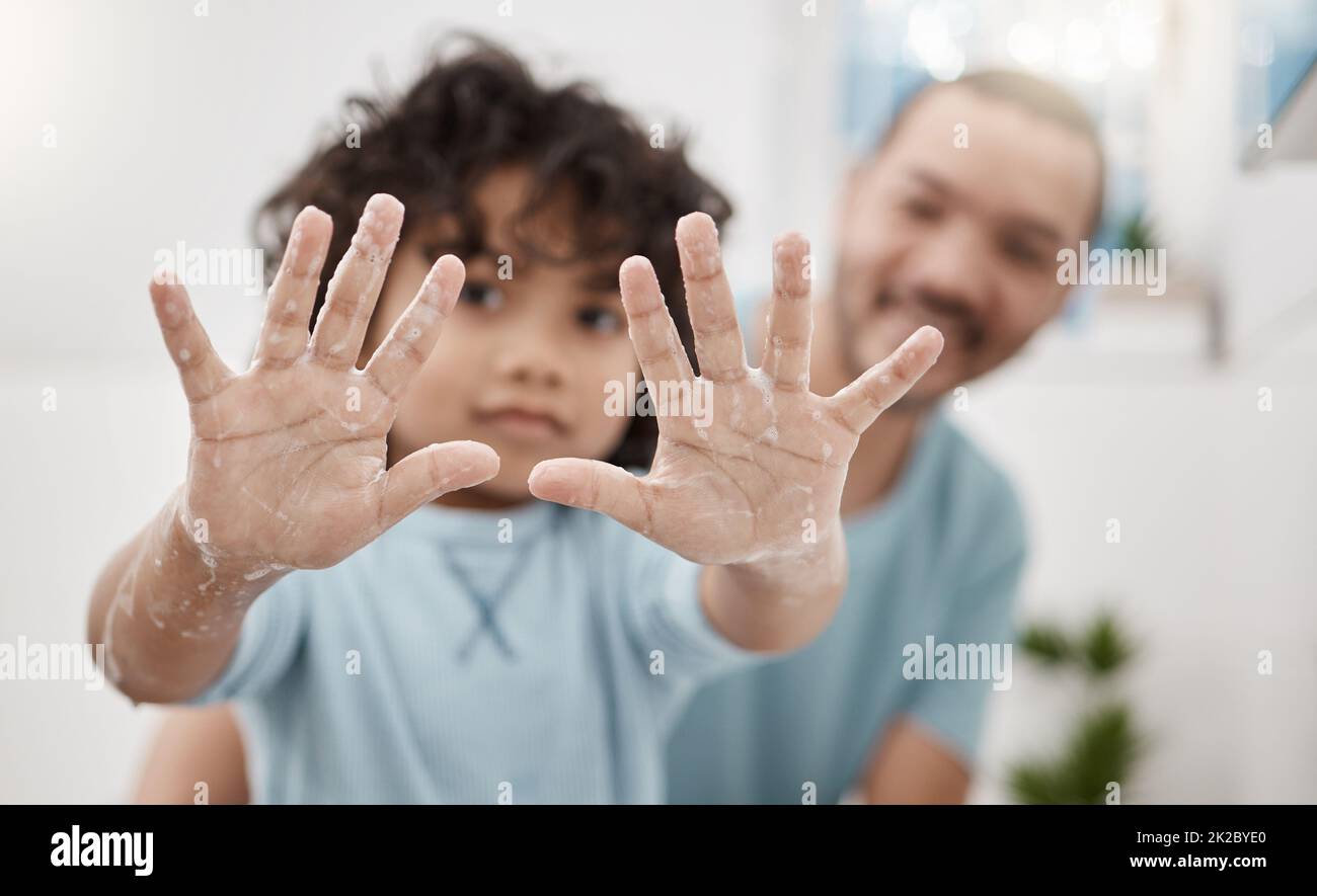 First we rub with soap, then we rinse. Portrait of a little boy holding ...