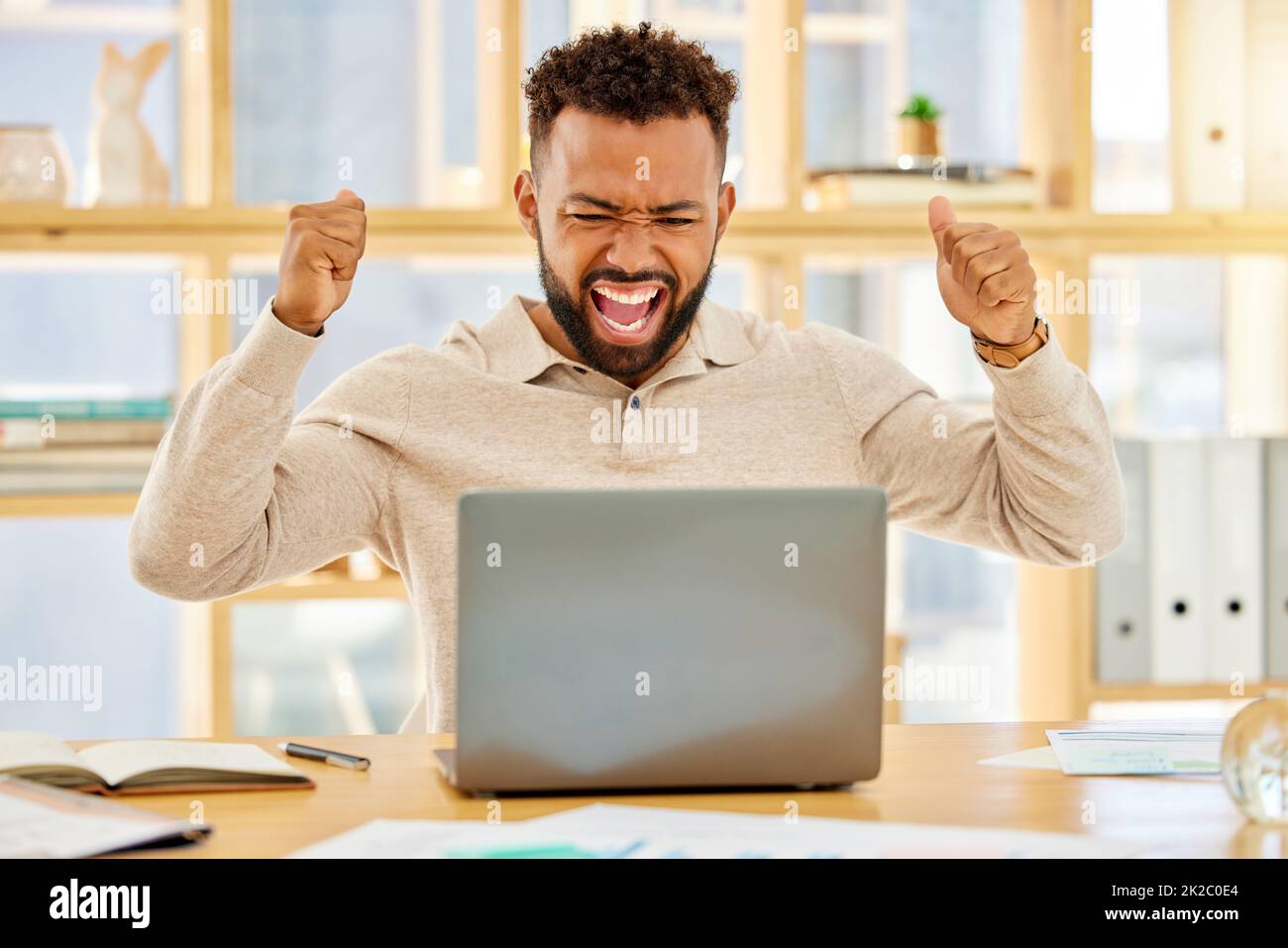 Black man, winner and celebrating stock sale, profit and success online ...
