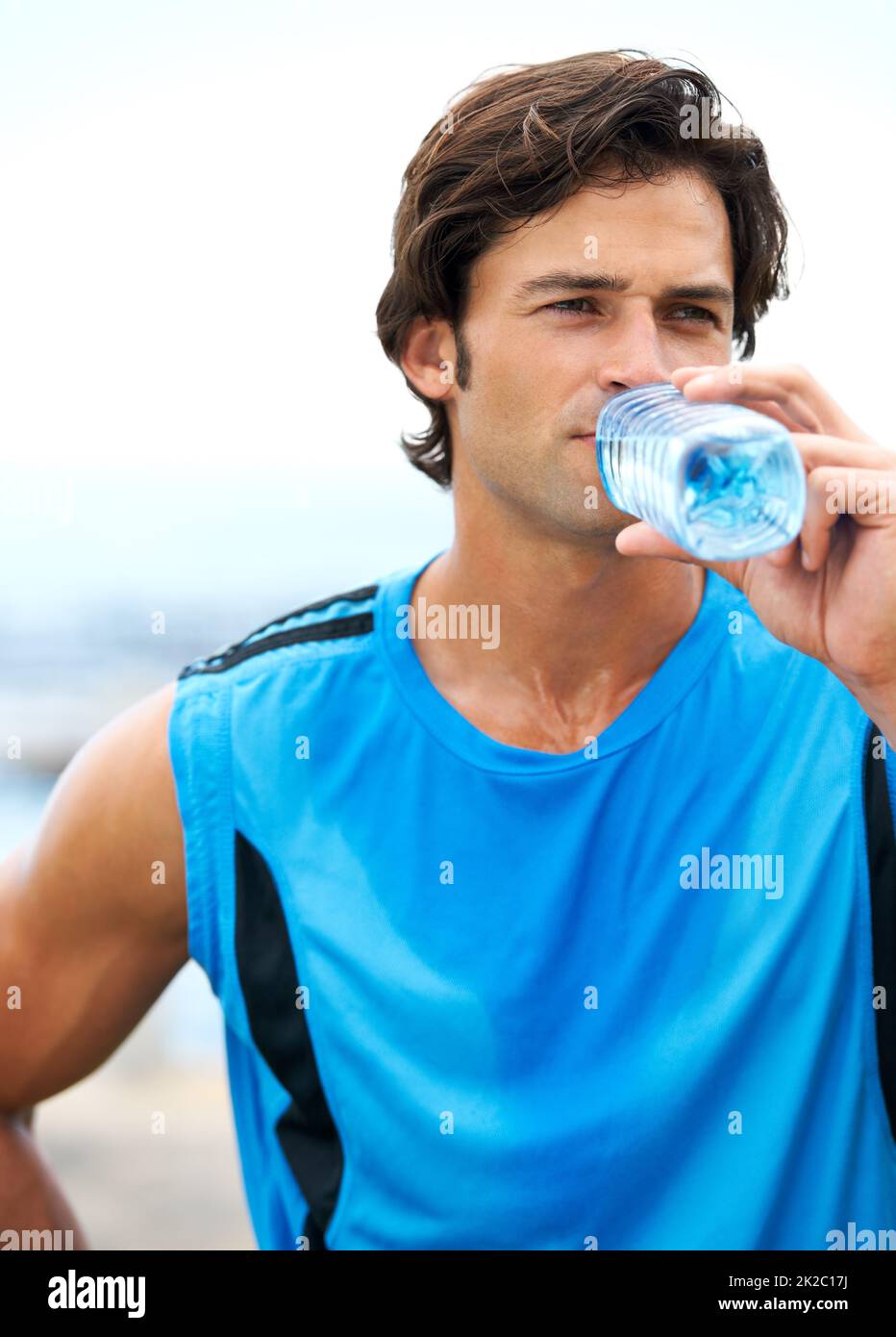 Ensure you drink enough water during training. A young and fit man ...