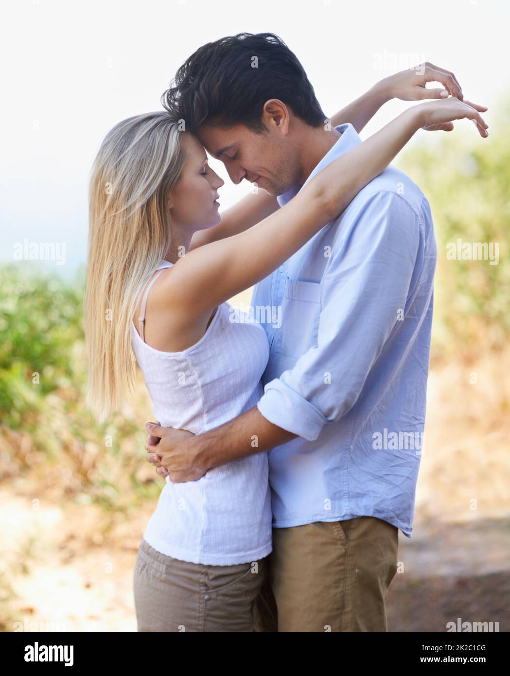 Lost in a romantic moment. Side view of a happy young couple embracing ...