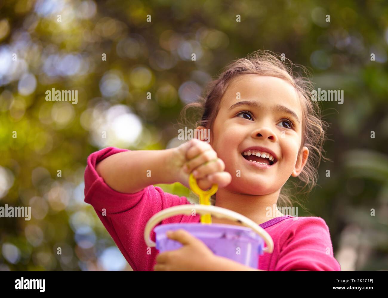 Summertime fun. Shot of a little girl playing outside in the mud Stock ...