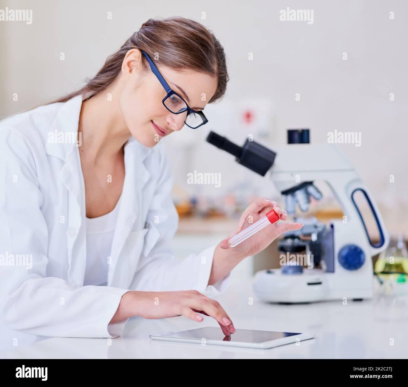 Digitally tracking her progress. Shot of a scientist using a digital ...