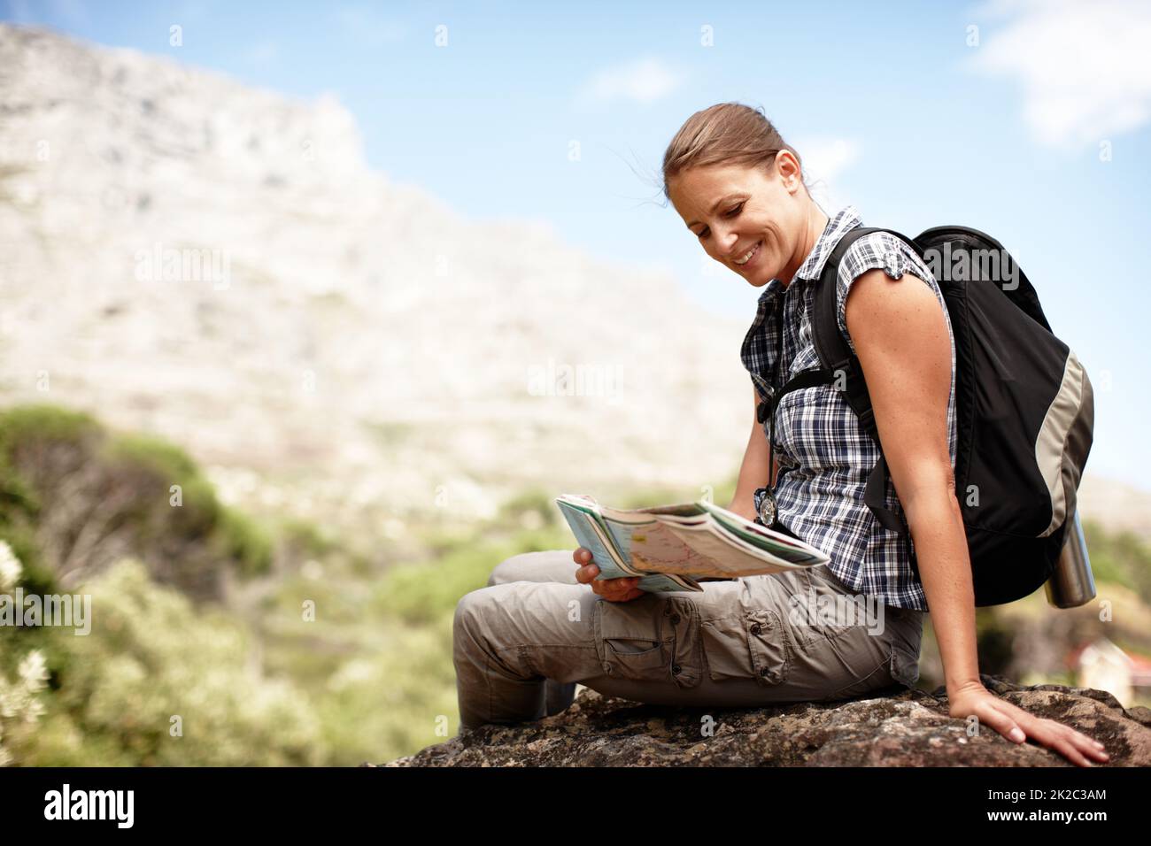 So many routes to be explored.... Young female hiker consulting her map ...