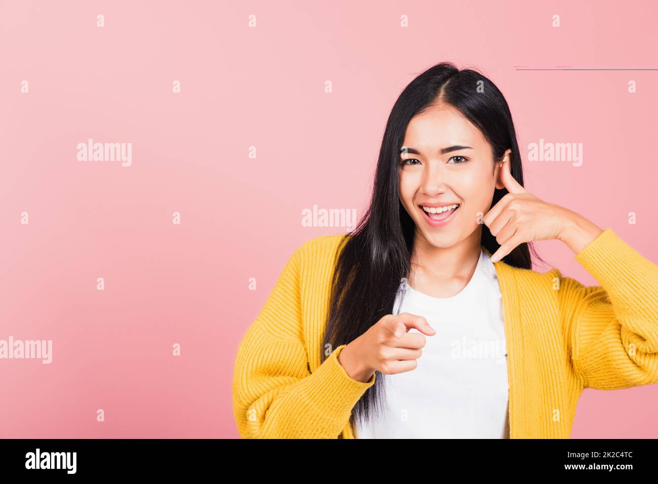 woman smiling doing phone gesture with hand fingers on telephone and ...