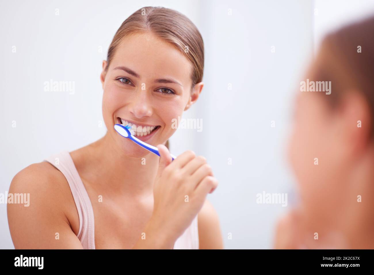 Taking care of her smile. A young woman brushing her teeth Stock Photo ...