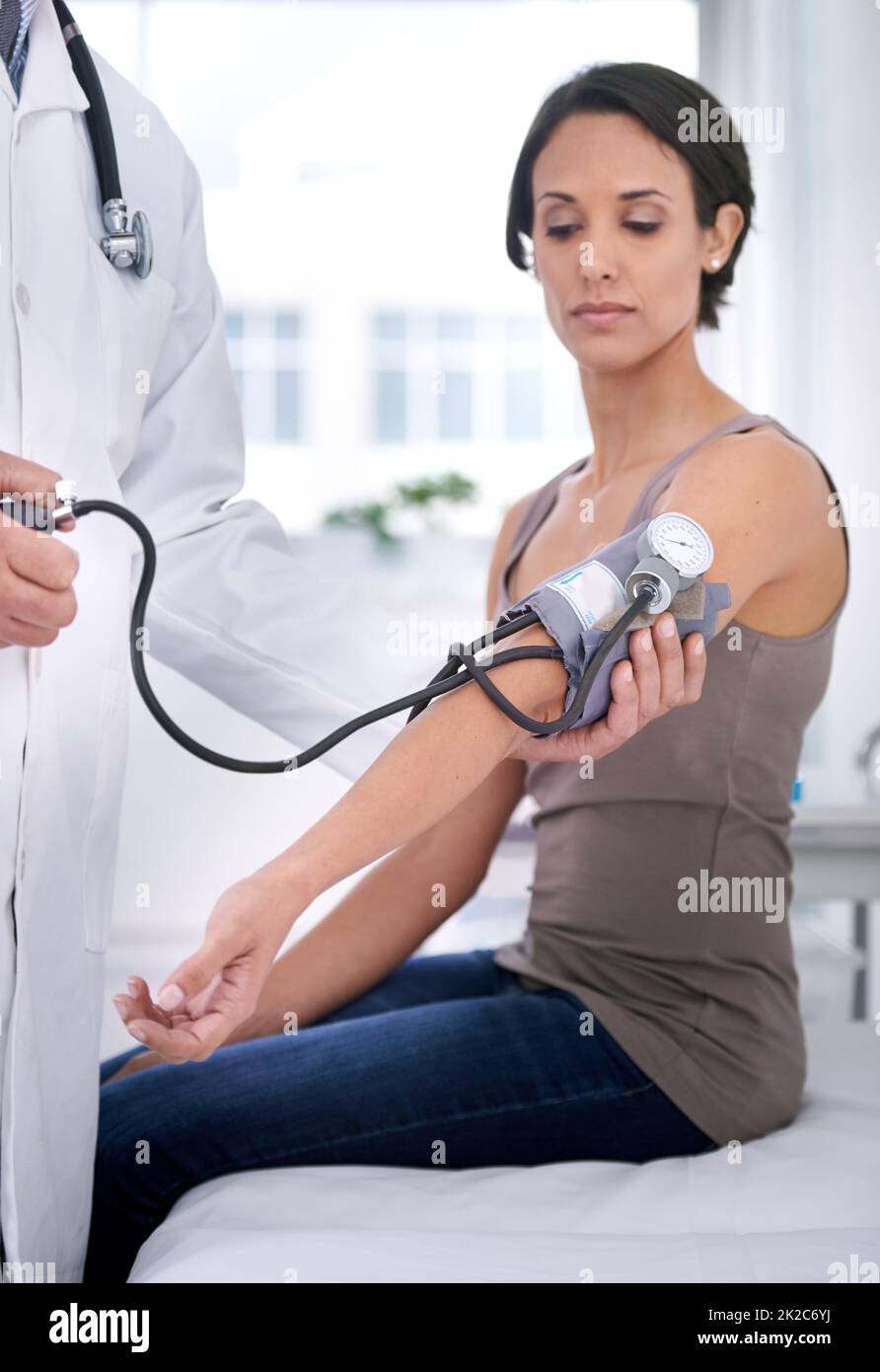 Female doctor checking blood pressure of a patient hi-res stock ...