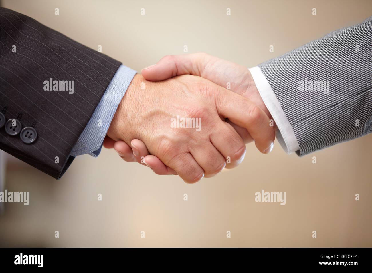 Shaking on it. Close up two businessmen shaking hands Stock Photo - Alamy