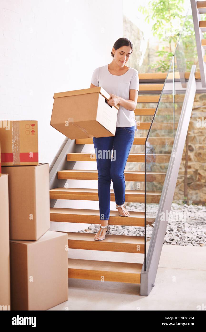 Unpacking her new life. A young woman surrounded by boxes Stock Photo ...