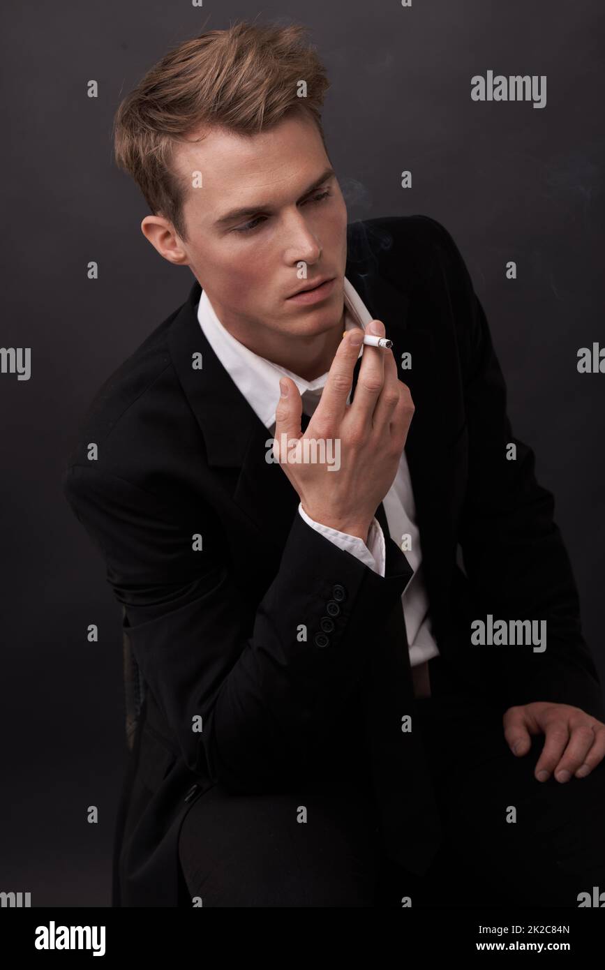 Handsome man smoking cigarette hi-res stock photography and images - Alamy