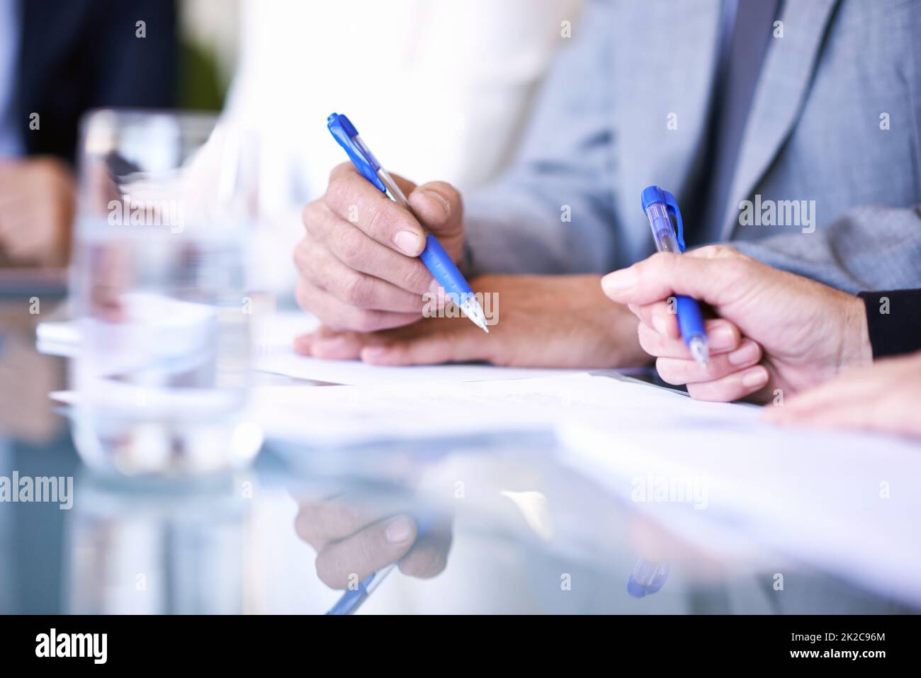 Signing on the dotted line. Cropped view of a group of businesspeople ...