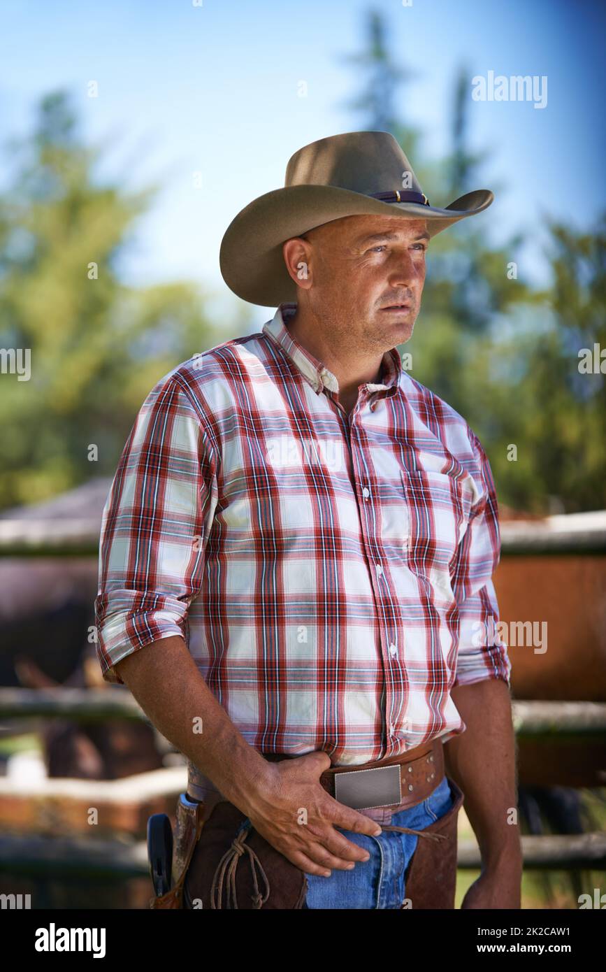 He knows how to take care of things. A mature cowboy outdoors on his ...
