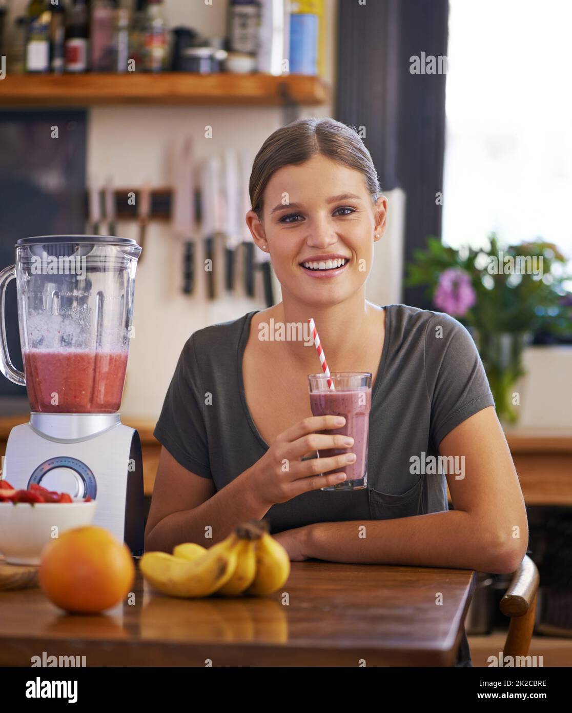 Savoring her fresh smoothie. Portrait of an attractive young woman ...