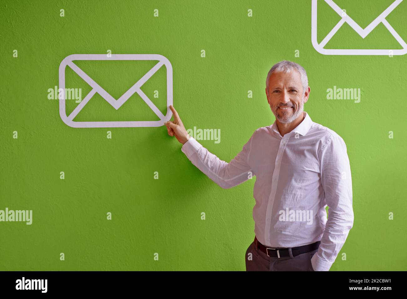 Check your inbox. A mature businessman pointing at a message symbol ...