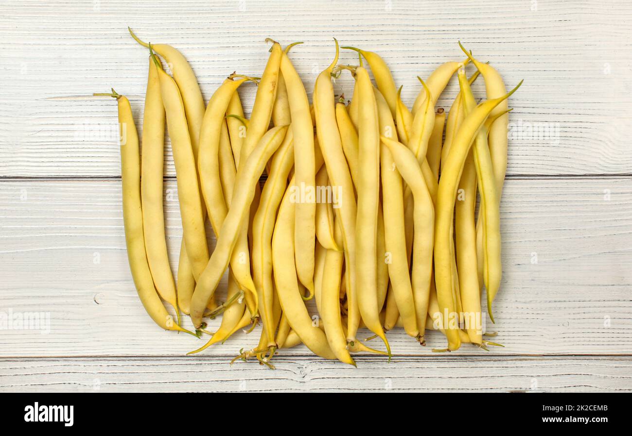 Yellow string (wax) beans on white boards. Tabletop view Stock Photo ...